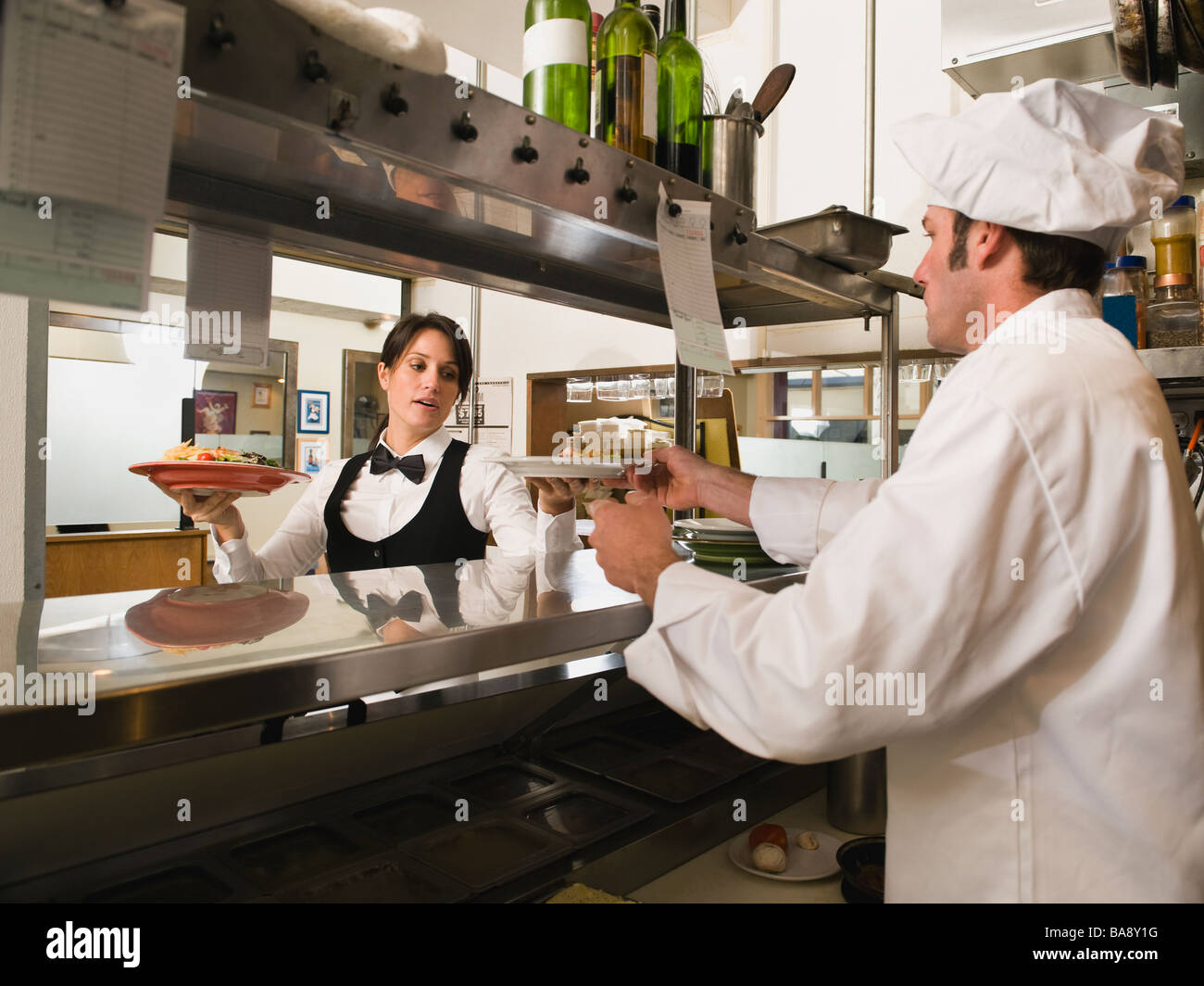 Chef giving waitress plates of food Stock Photo - Alamy
