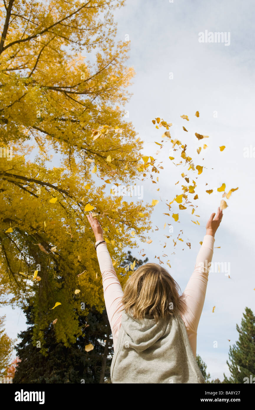 Woman throwing autumn leaves in air Stock Photo - Alamy