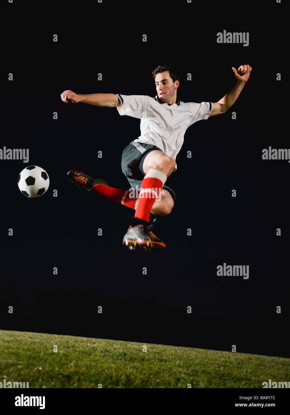 Soccer player kicking ball Stock Photo - Alamy