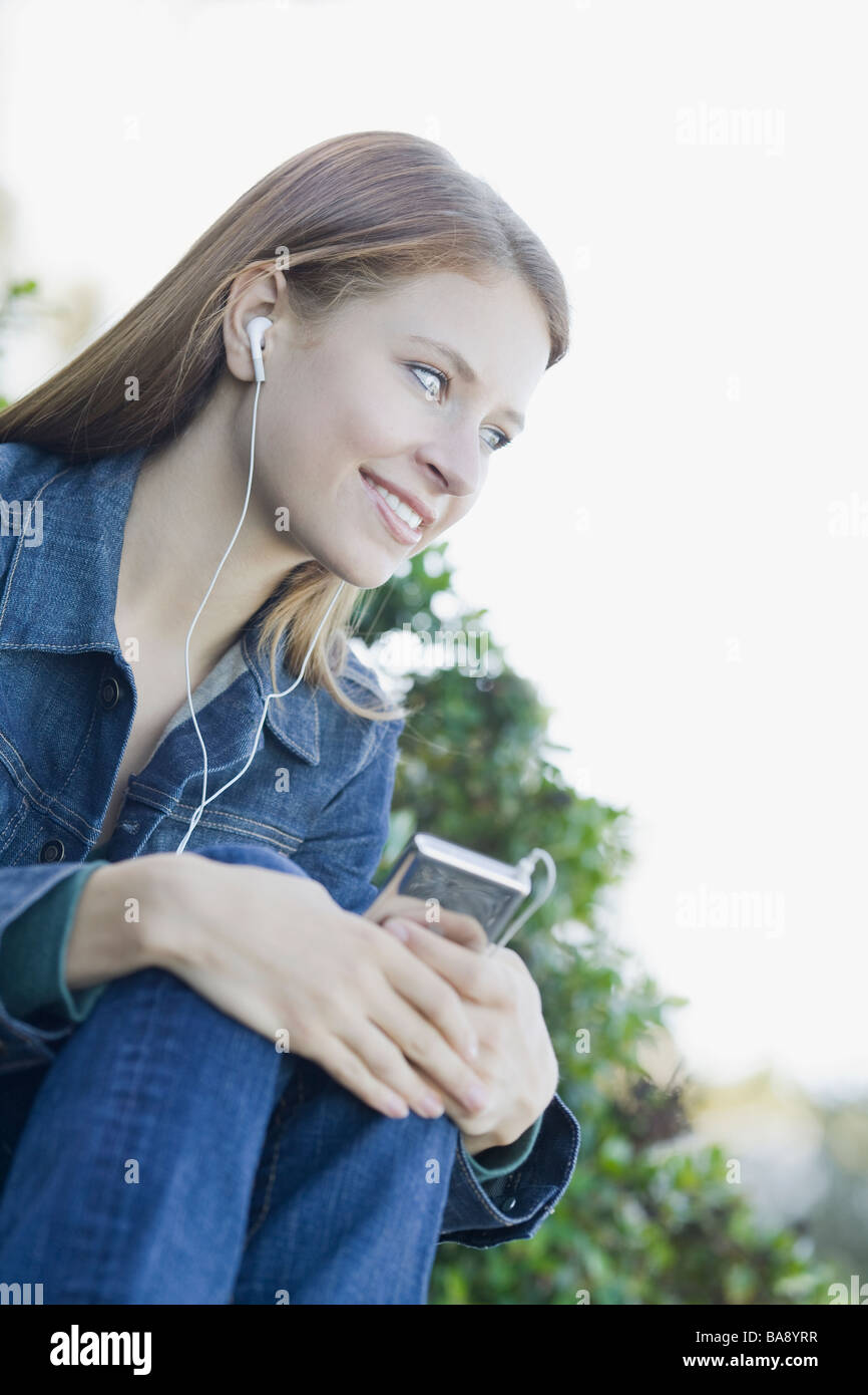 Young woman listening to mp3 player Stock Photo - Alamy