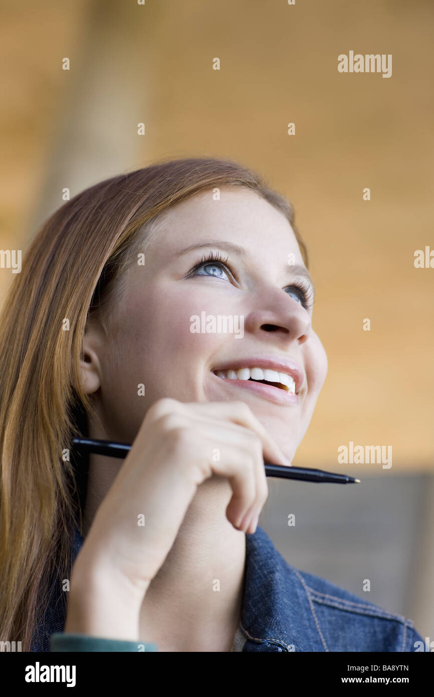 Young woman holding pen Stock Photo - Alamy