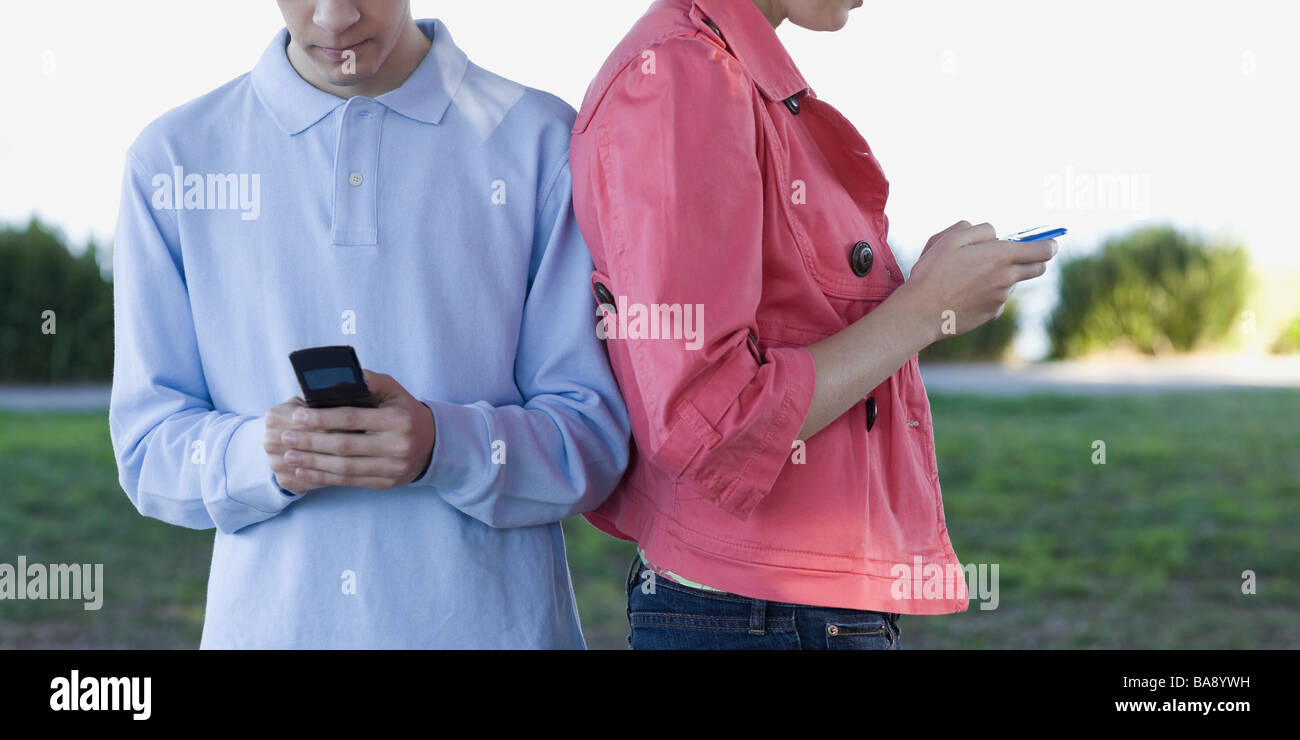 Young couple text messaging outdoors Stock Photo - Alamy