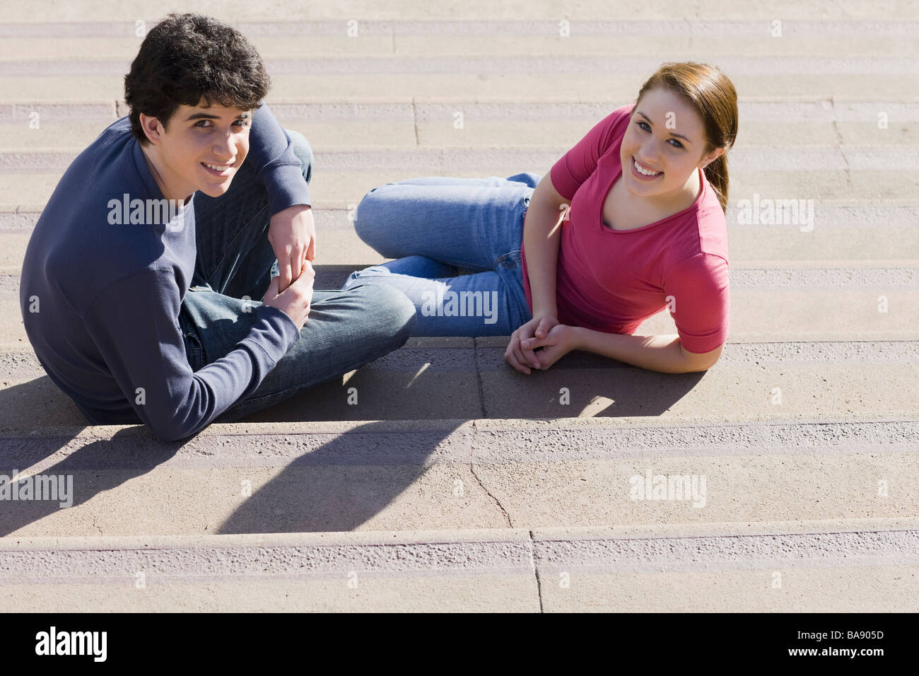 Friends sitting on steps Stock Photo - Alamy