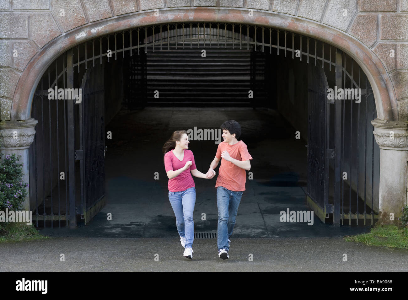 Young couple running through tunnel Stock Photo - Alamy