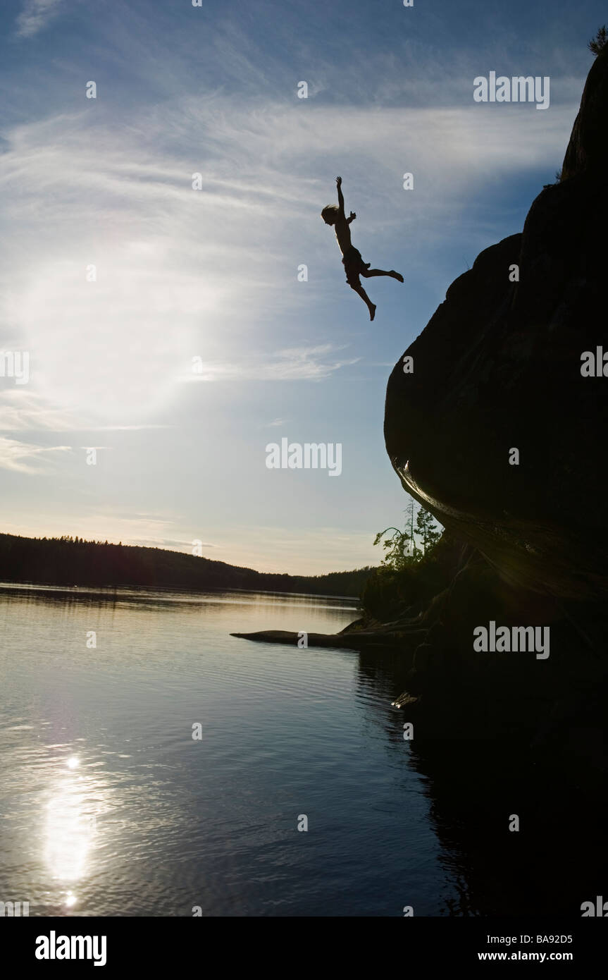 A man jumping from a cliff Sweden Stock Photo - Alamy