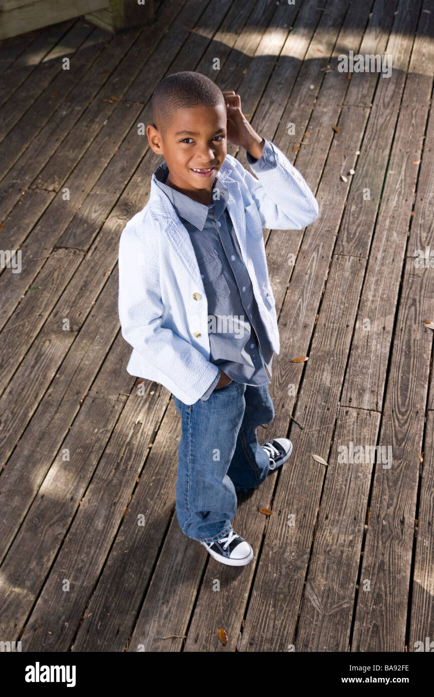 High angle view of African American boy standing on wooden boardwalk in ...