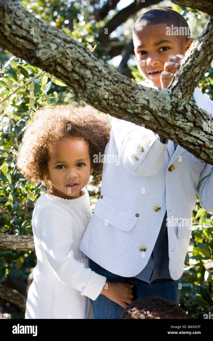 Portrait of African American children standing near tree Stock Photo ...