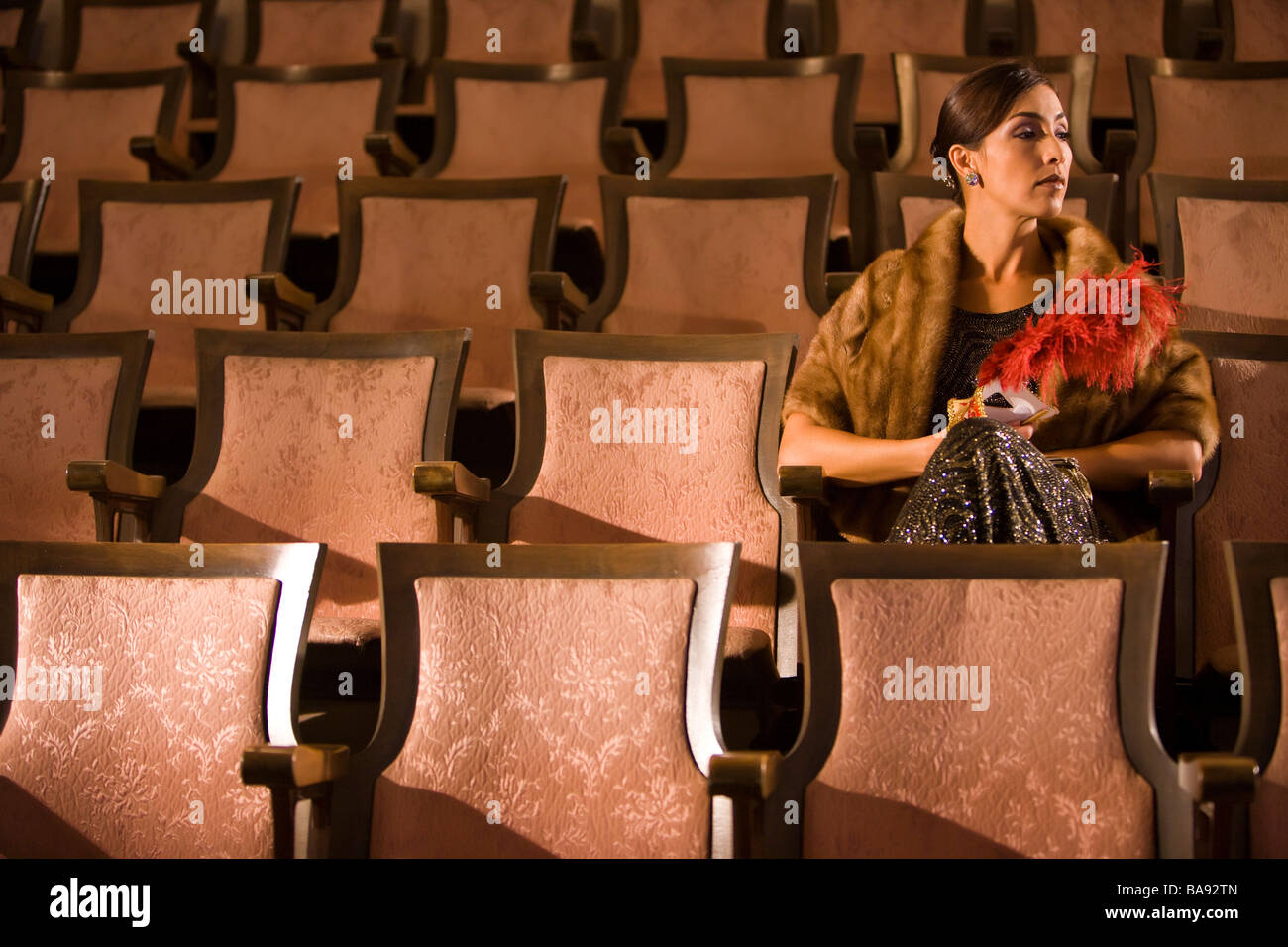 Hispanic woman in formal gown sitting in theater Stock Photo - Alamy