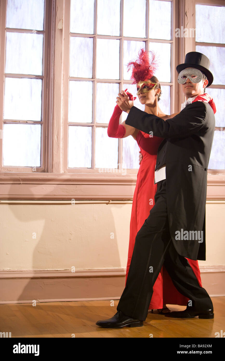 Couple in masquerade costumes dancing together Stock Photo - Alamy