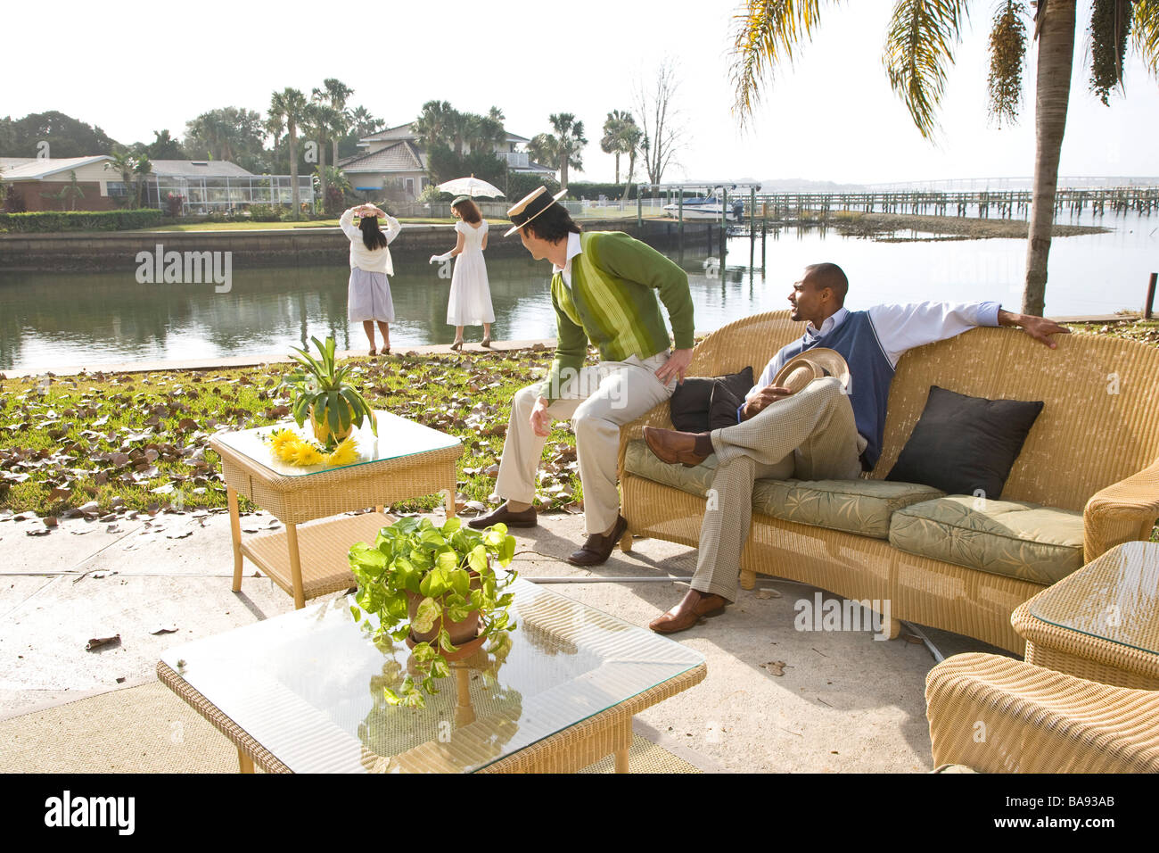 Portrait of 1920s socialite men watching ladies on water's edge at ...