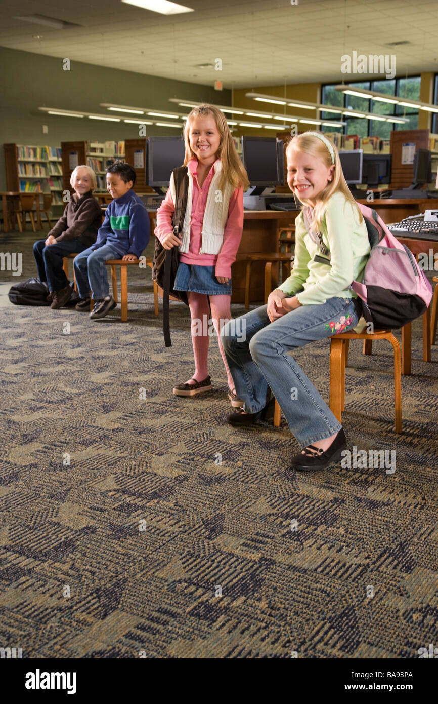 Pupils smiling camera in library hi-res stock photography and images ...