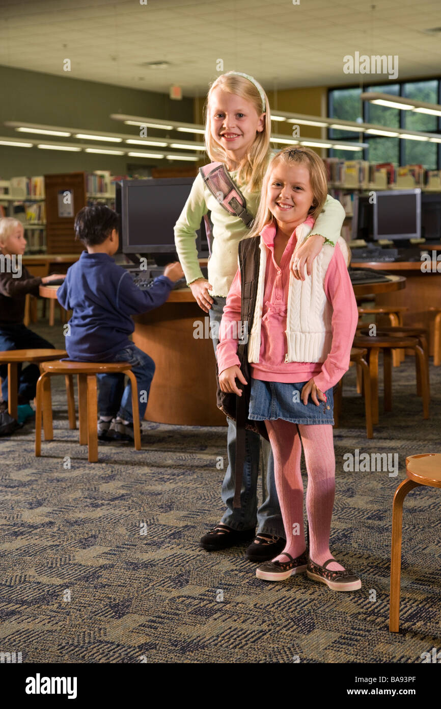 Portrait of two elementary school girls in library Stock Photo - Alamy