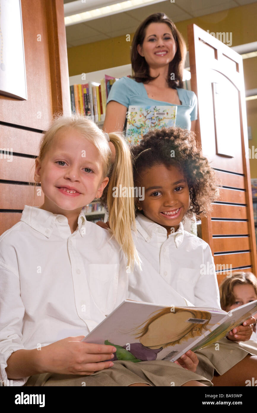 Portrait of elementary school teacher with pupils in library Stock ...
