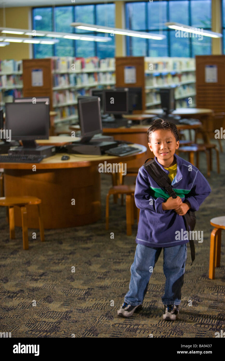 Asian boy standing in school library Stock Photo - Alamy
