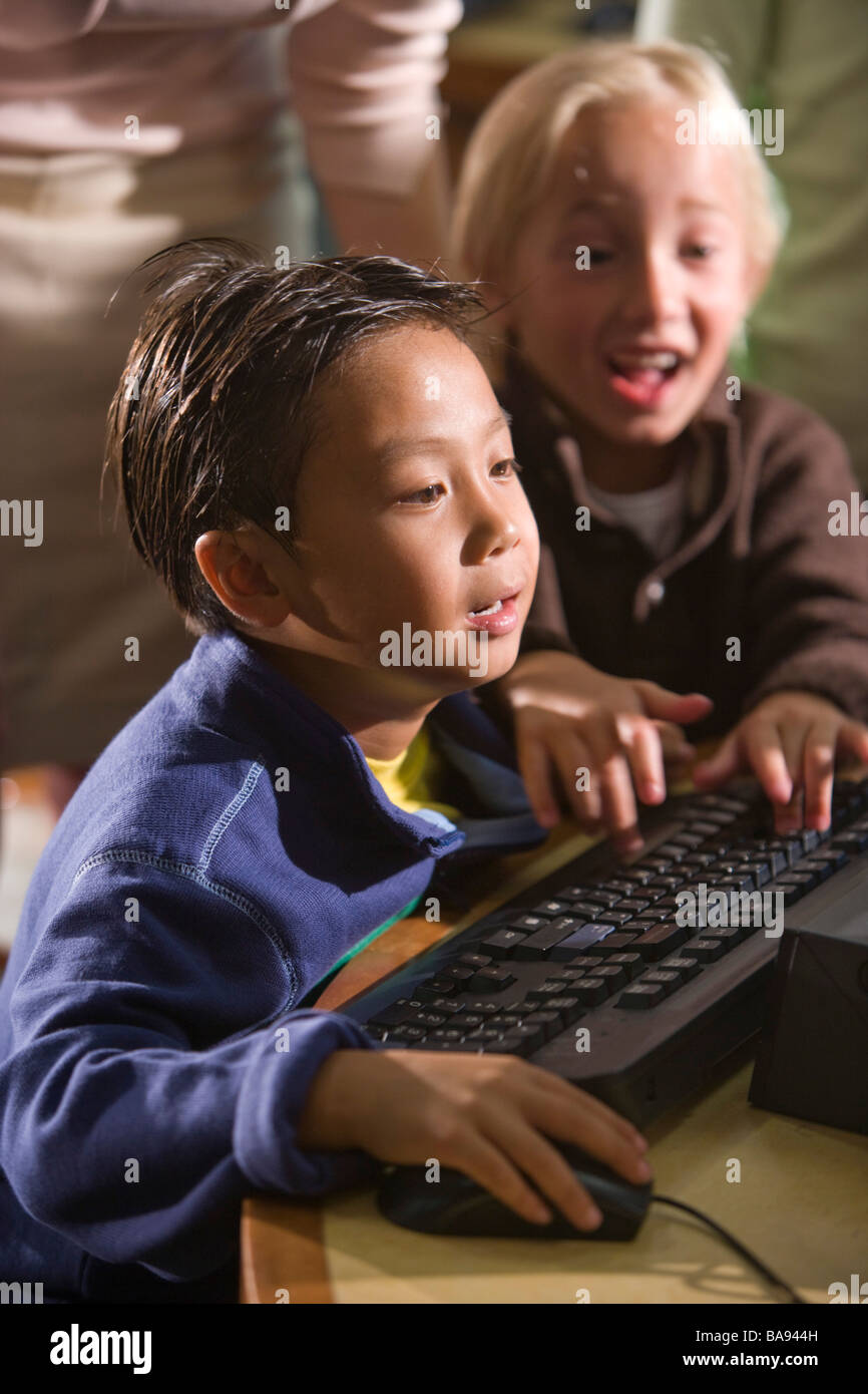 Two elementary school boys using computer in library, side view Stock ...