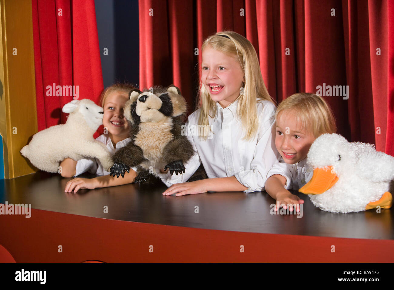 Three elementary school children performing puppet show Stock Photo - Alamy