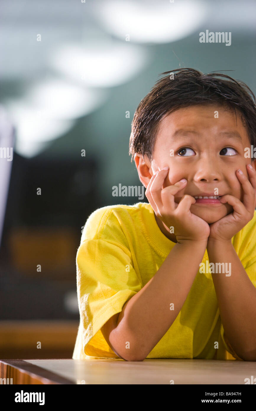 Asian school boy looking worried in school library Stock Photo - Alamy