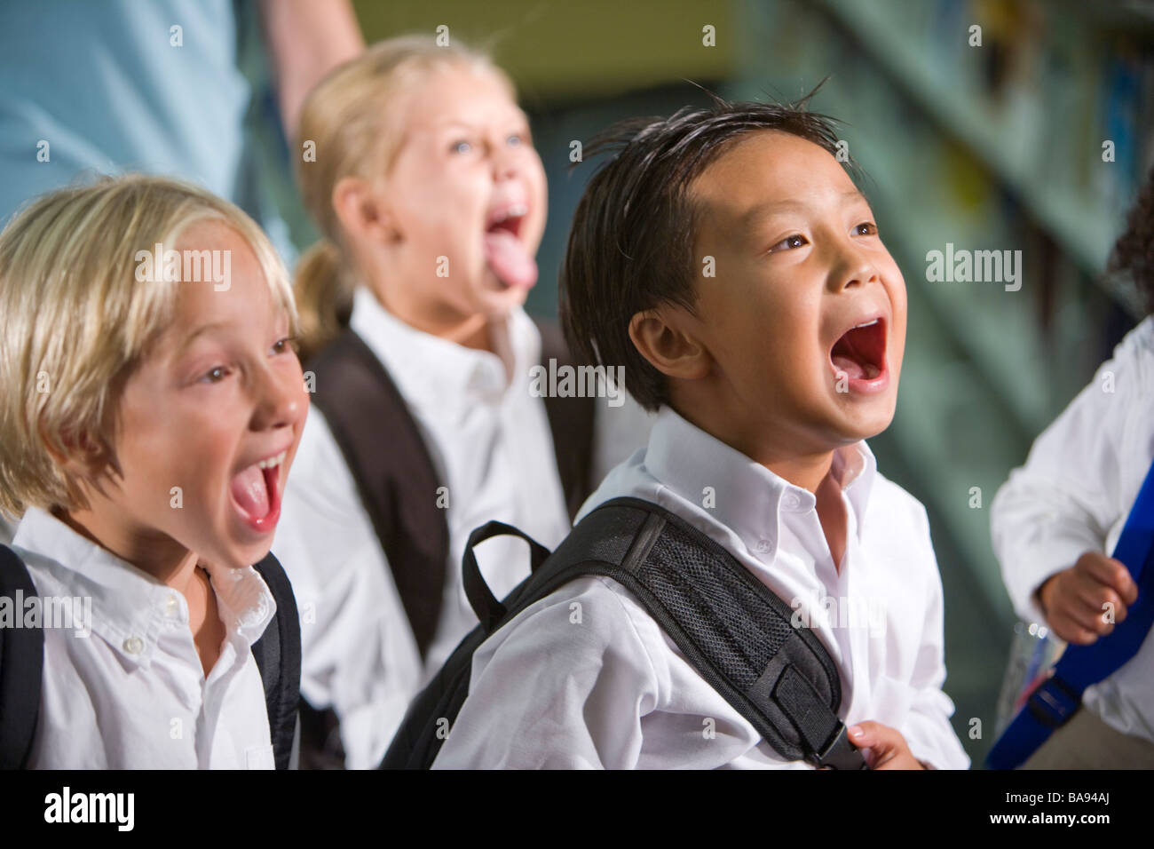 Asian and Caucasian elementary school pupils shouting in library Stock ...