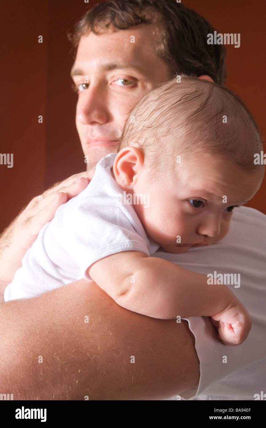 Portrait of father holding 3 month old baby over his shoulder Stock ...