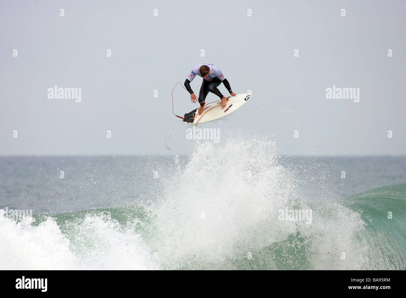 Surfer perfoming a Jump of a Wave Stock Photo - Alamy
