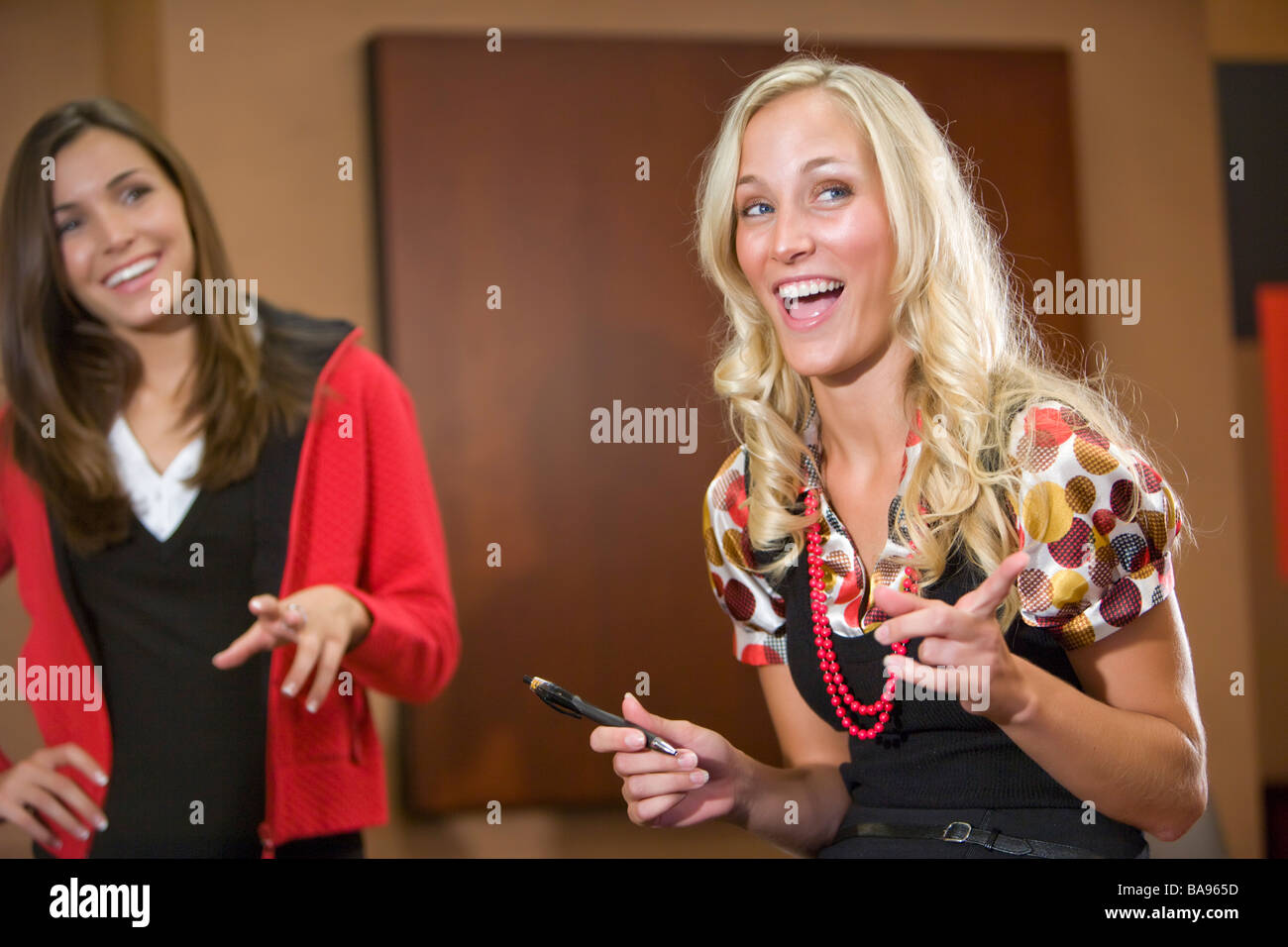 Two female office workers conversing in boardroom Stock Photo - Alamy