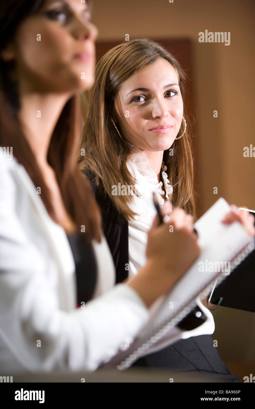 Two pretty young women taking notes Stock Photo - Alamy