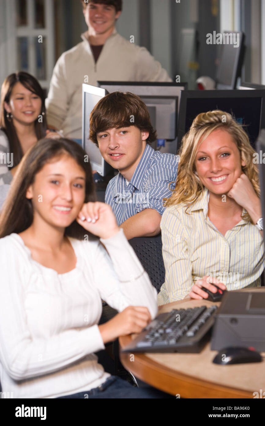 Portrait of teenage students sitting at computers in library Stock ...