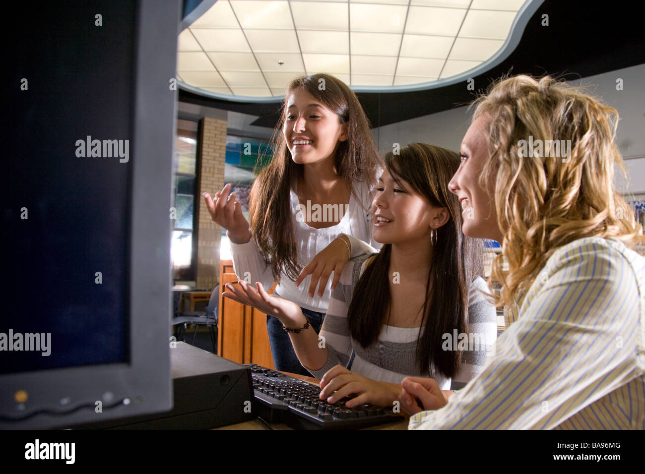 Teenage girls using computers in library Stock Photo - Alamy