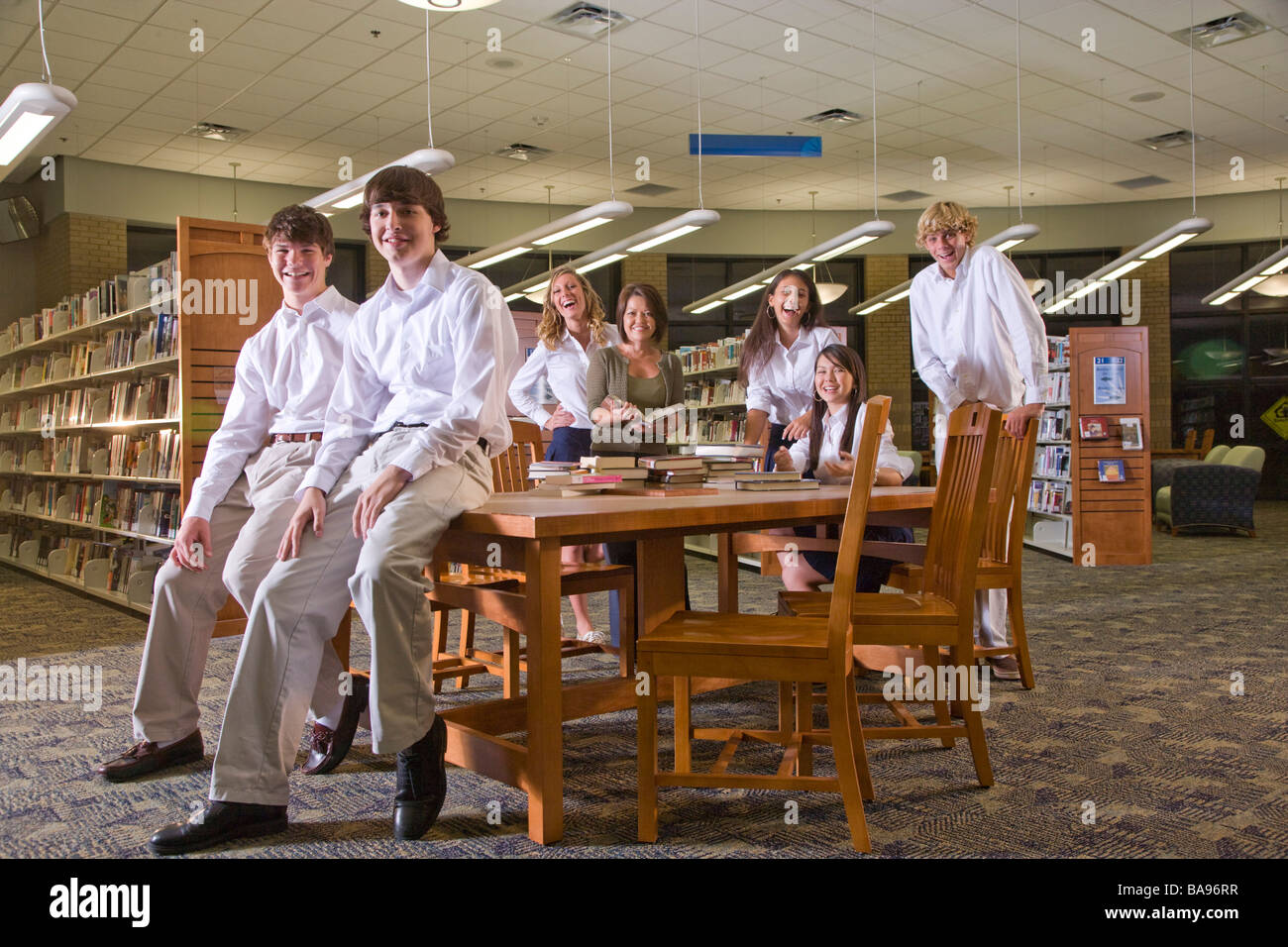 Portrait of school teacher and students in library Stock Photo - Alamy