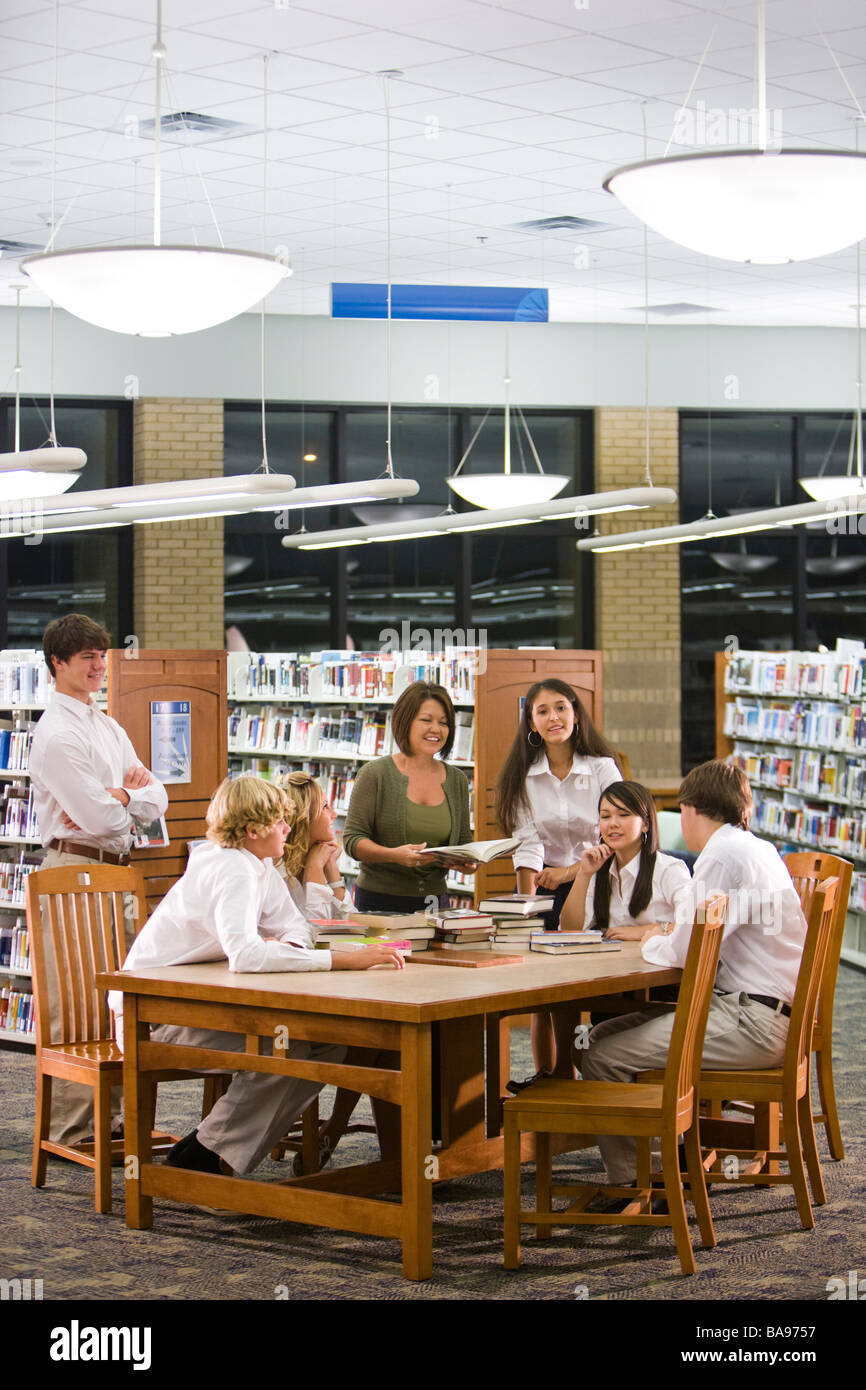 High school teacher and students in library Stock Photo - Alamy