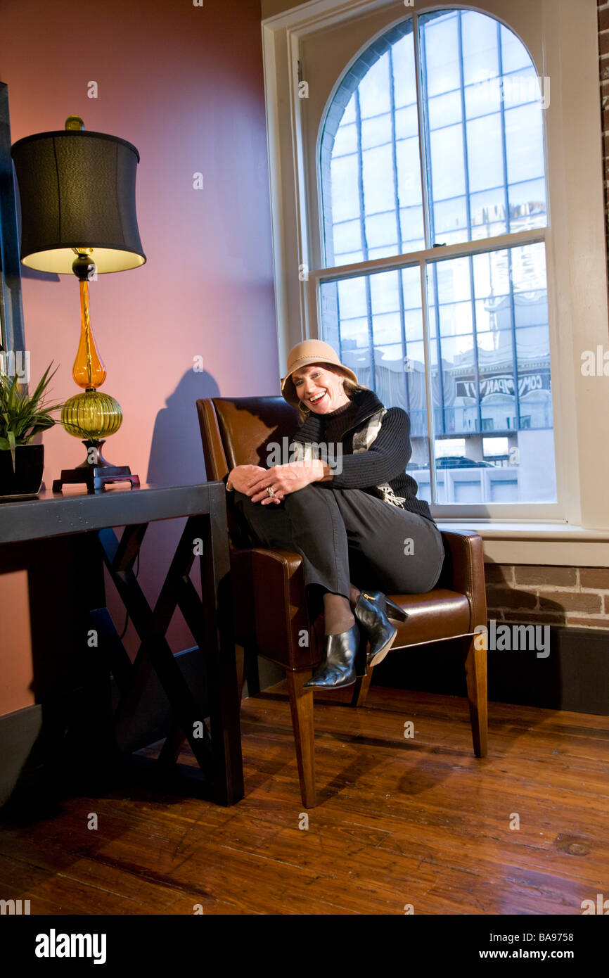 Middle-aged woman sitting in modern downtown loft Stock Photo - Alamy