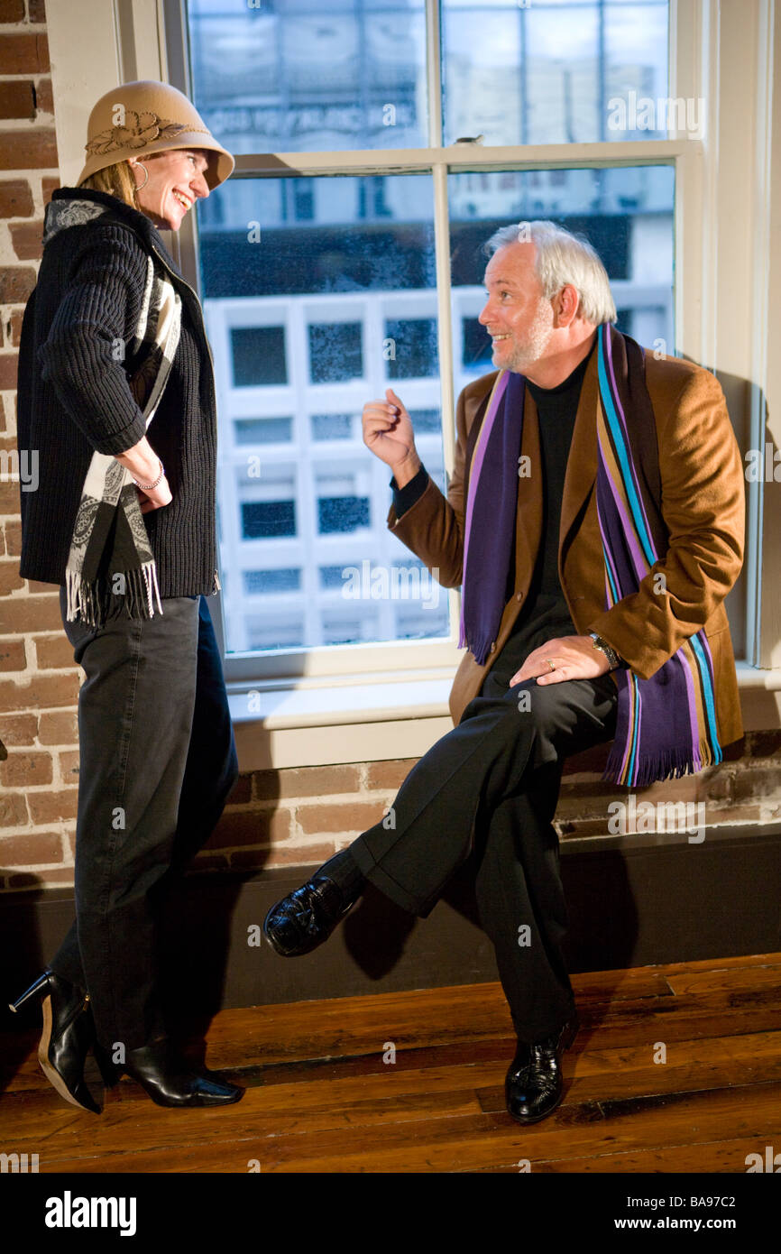 Middle-aged couple talking near window in modern downtown loft Stock ...