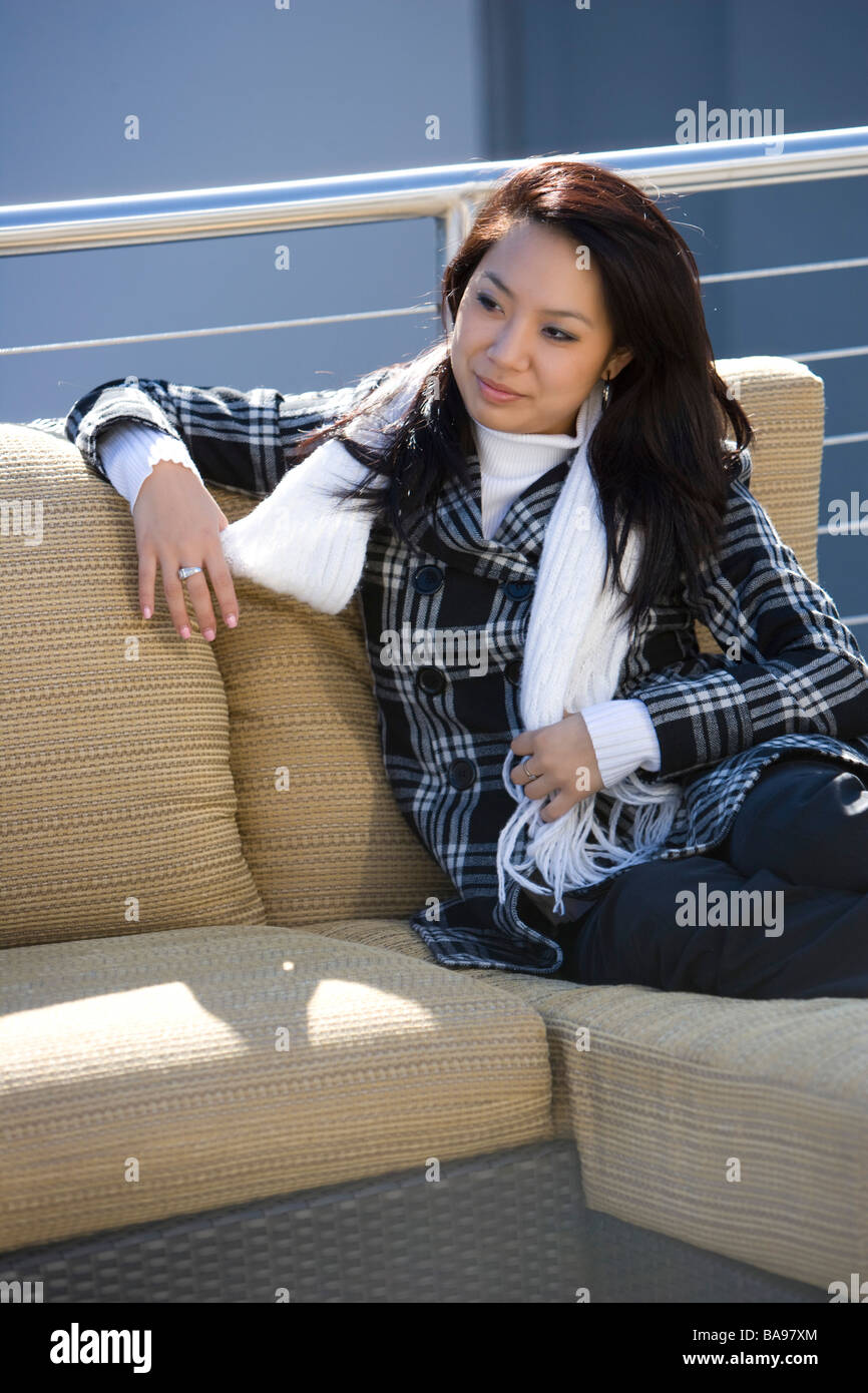 Young Asian woman sitting on rooftop of downtown condo in city Stock ...