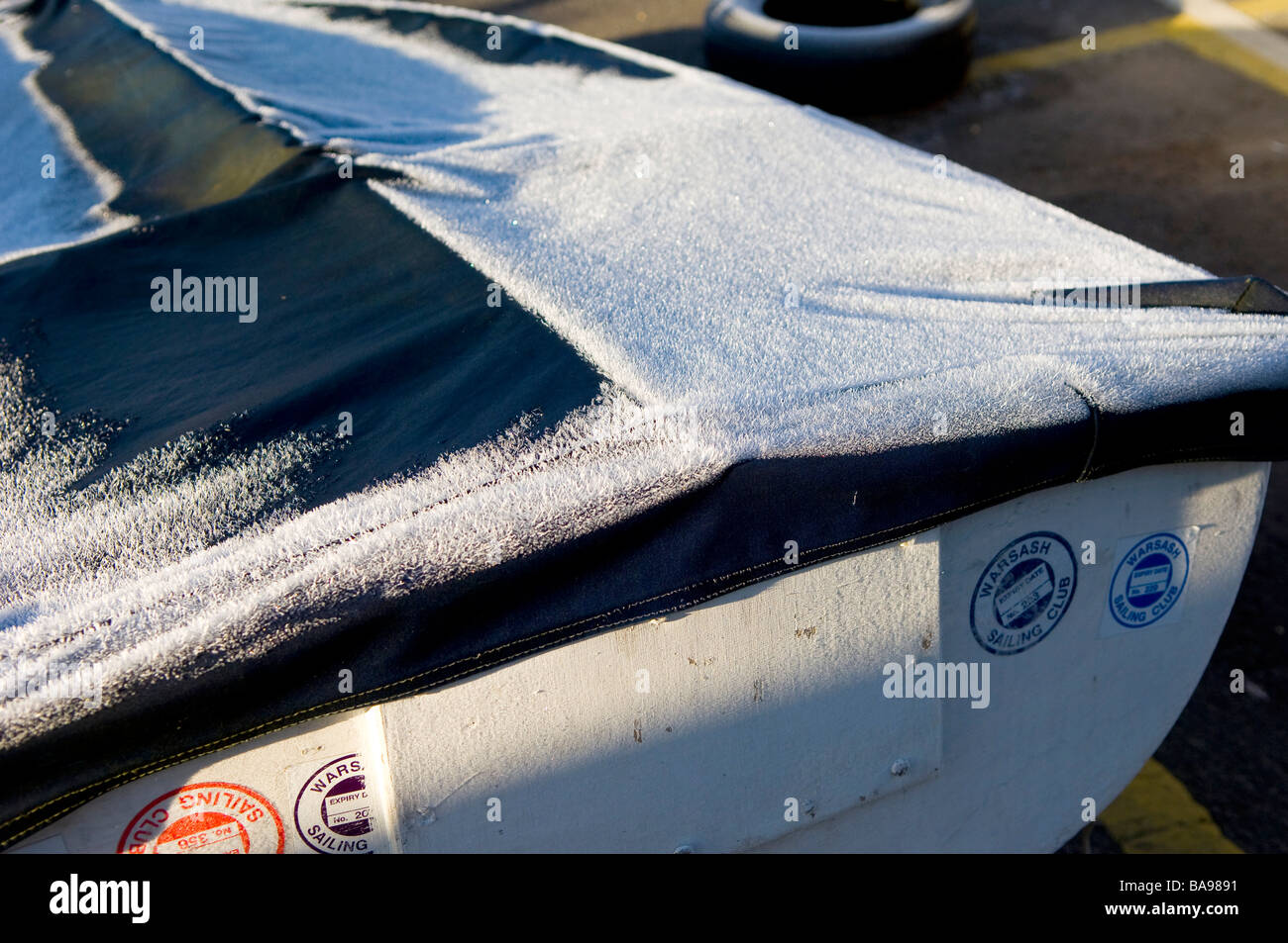 A small sail boat covered in frost and ice after a very cold night ...