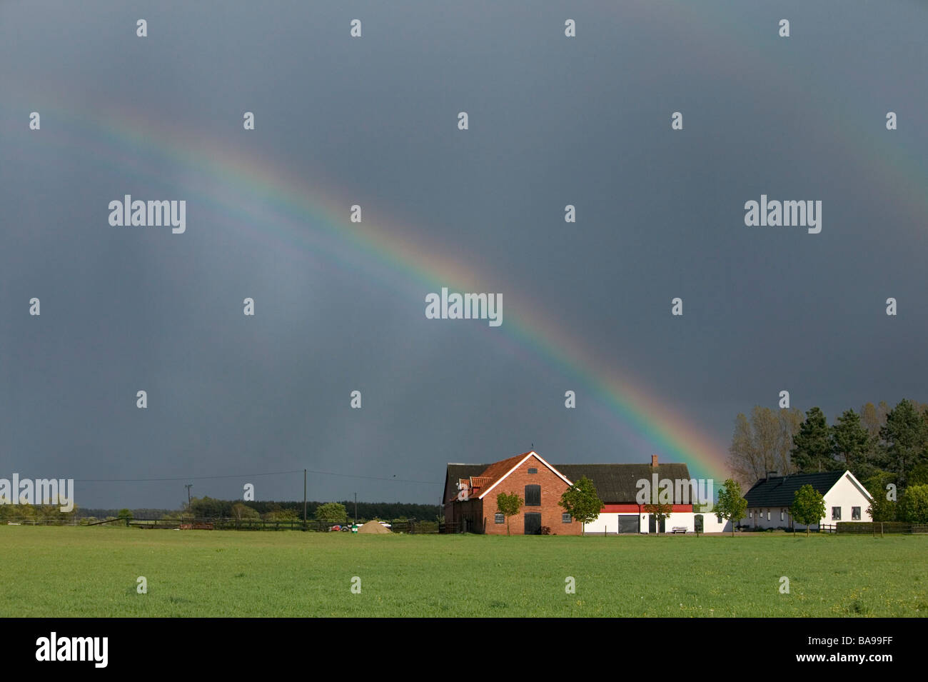 Rainbow over a farm Sweden Stock Photo - Alamy