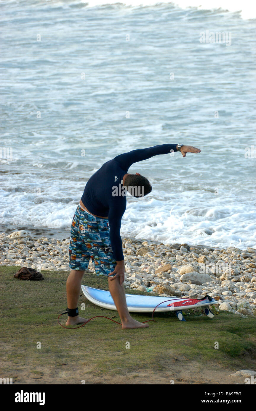 A Surfer stretches before entering the water and riding the waves at ...
