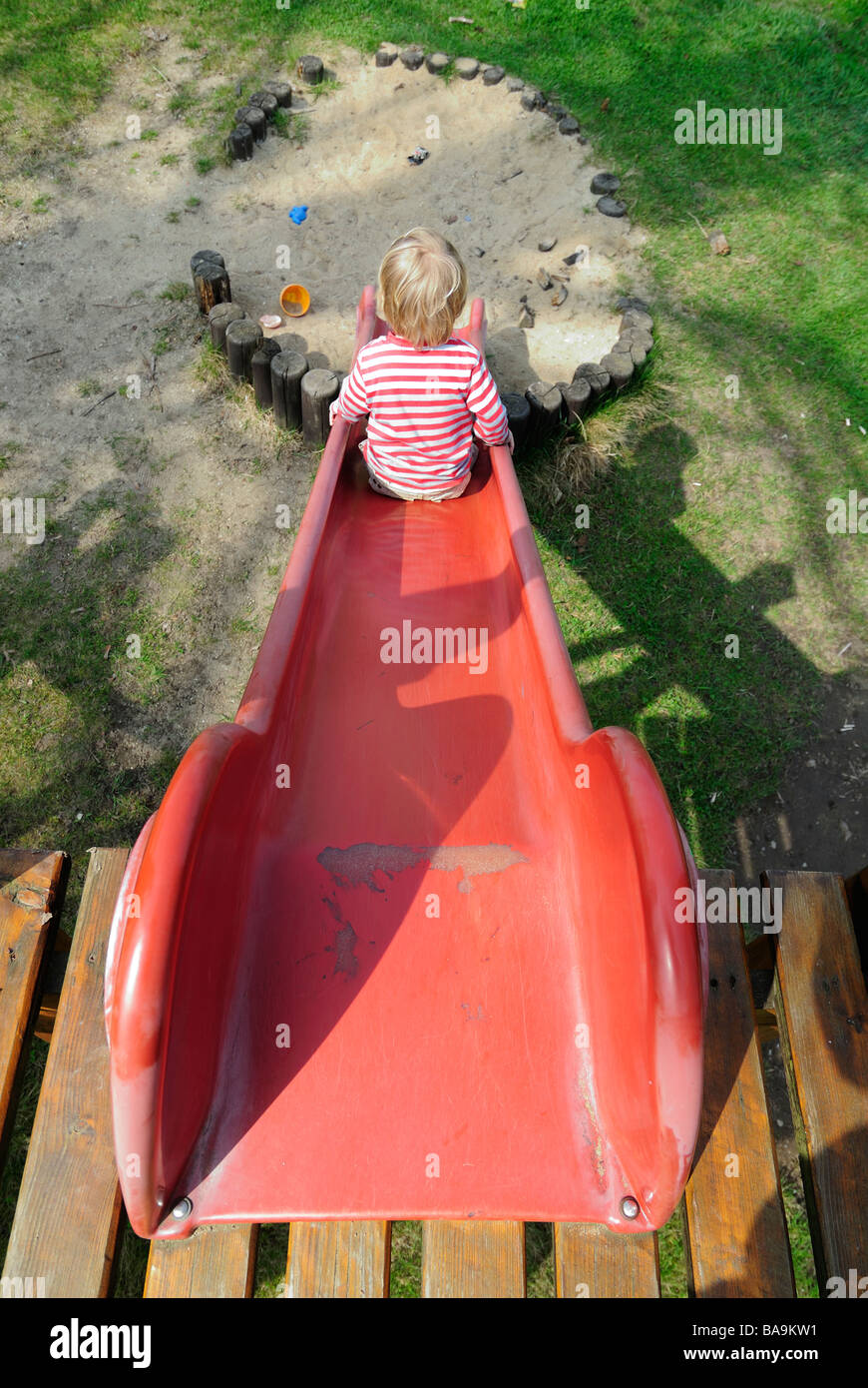 Child blonde boy sliding down the slide on the playground Stock Photo ...