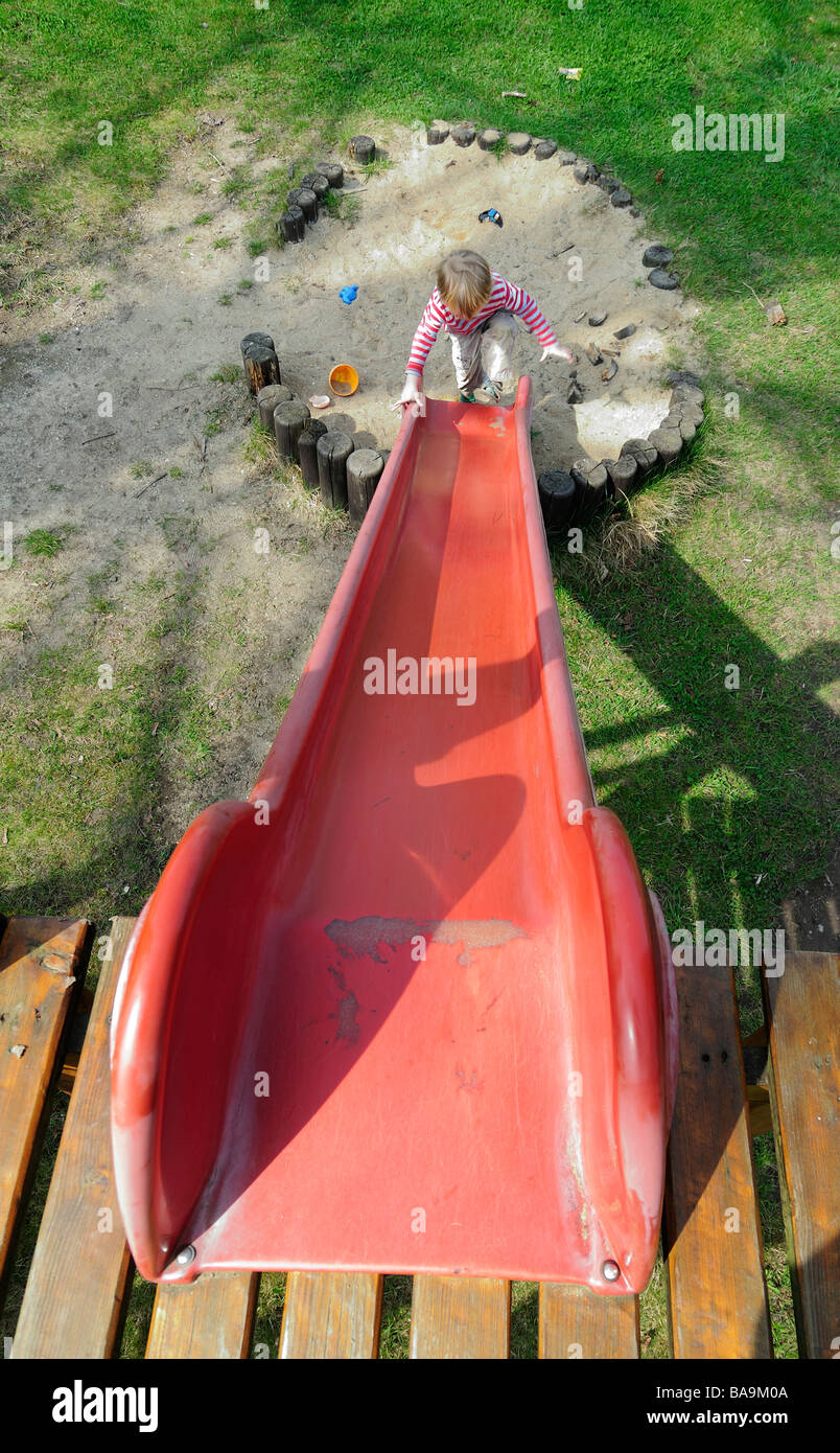 Child blonde boy sliding down the slide on the playground Stock Photo ...