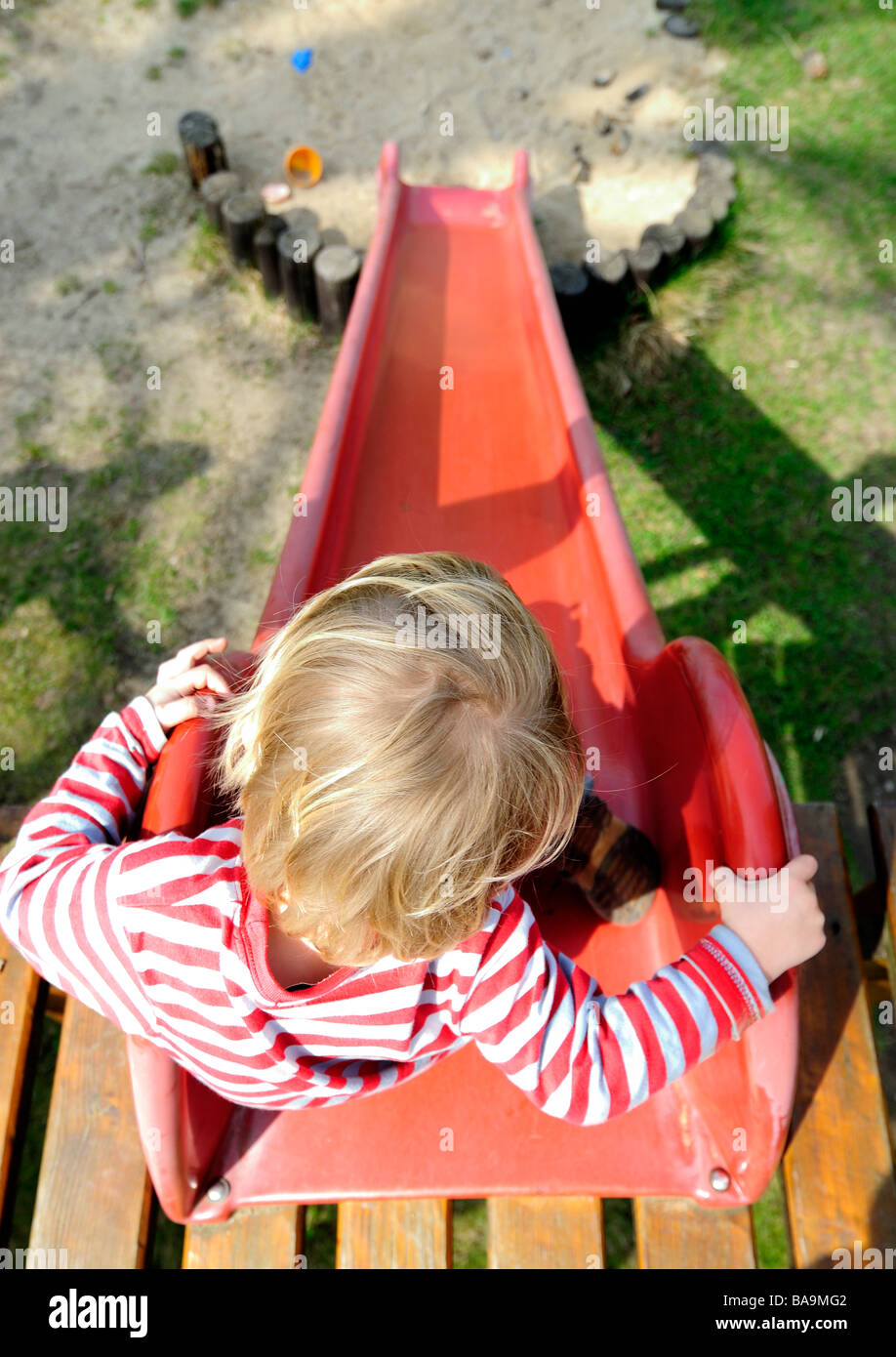 Child blonde boy sliding down the slide on the playground Stock Photo ...