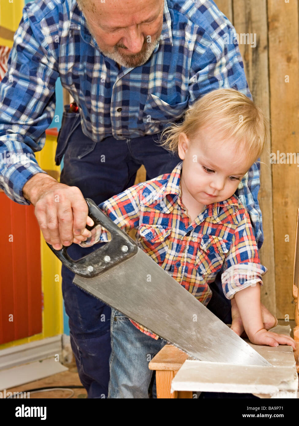 A senior man doing carpentry with his grandchild, Sweden Stock Photo ...