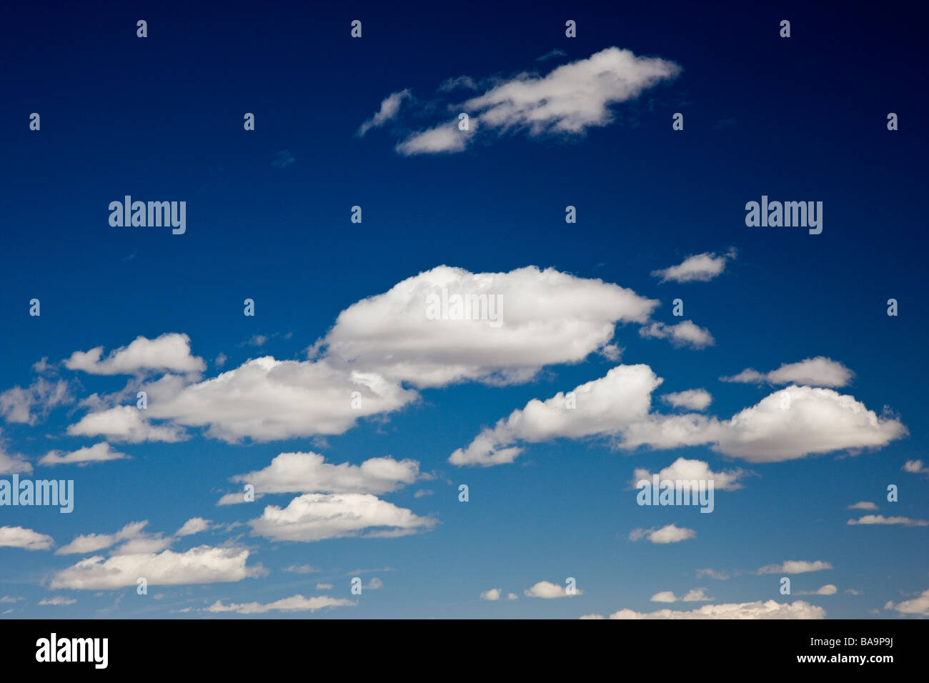 Puffy white clouds against a clear blue Colorado sky near Highway 50 ...