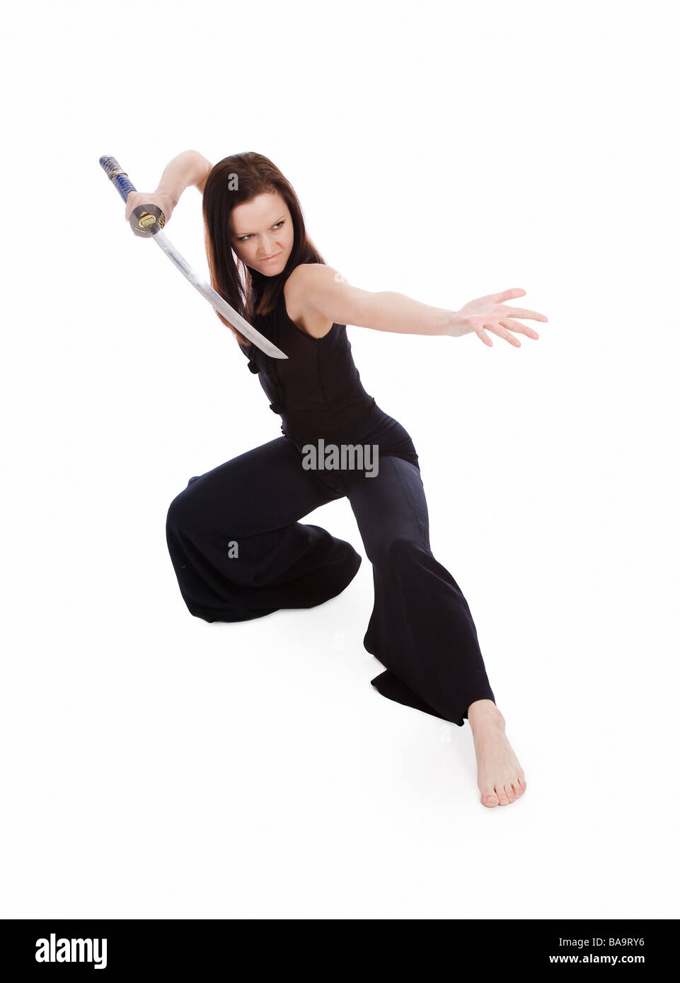 Beautiful woman in an aggressive posture with a sword on a white ...