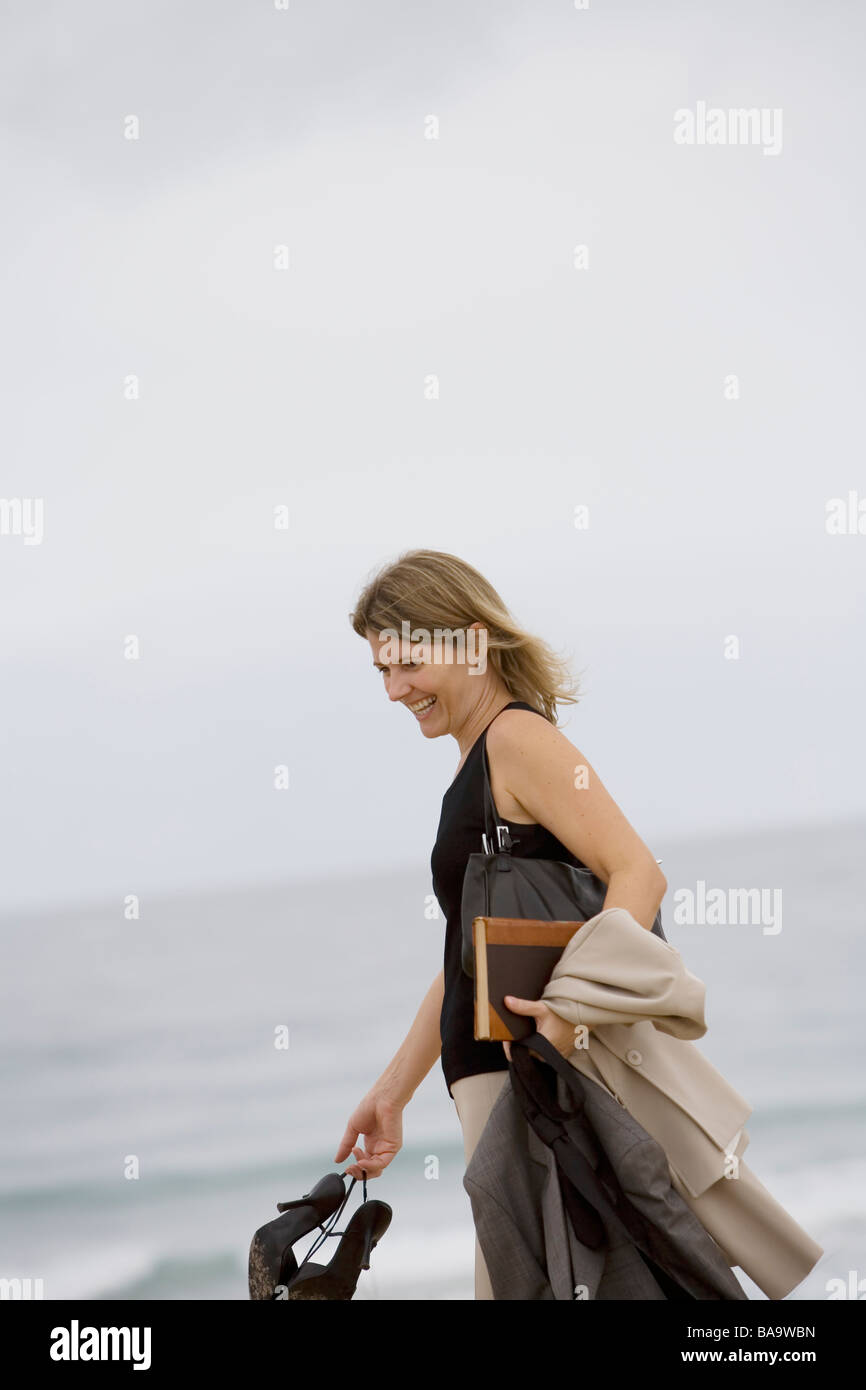 A Scandinavian woman carrying shoes on the beach, Brazil Stock Photo ...