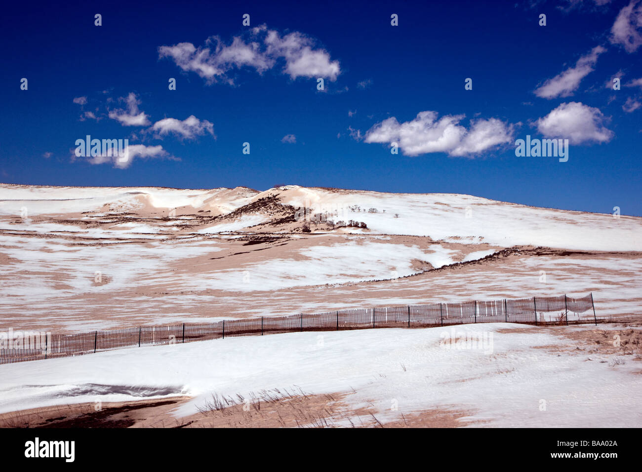 Winter snow is pink with wind blown sand and grit Highway 50 near the ...
