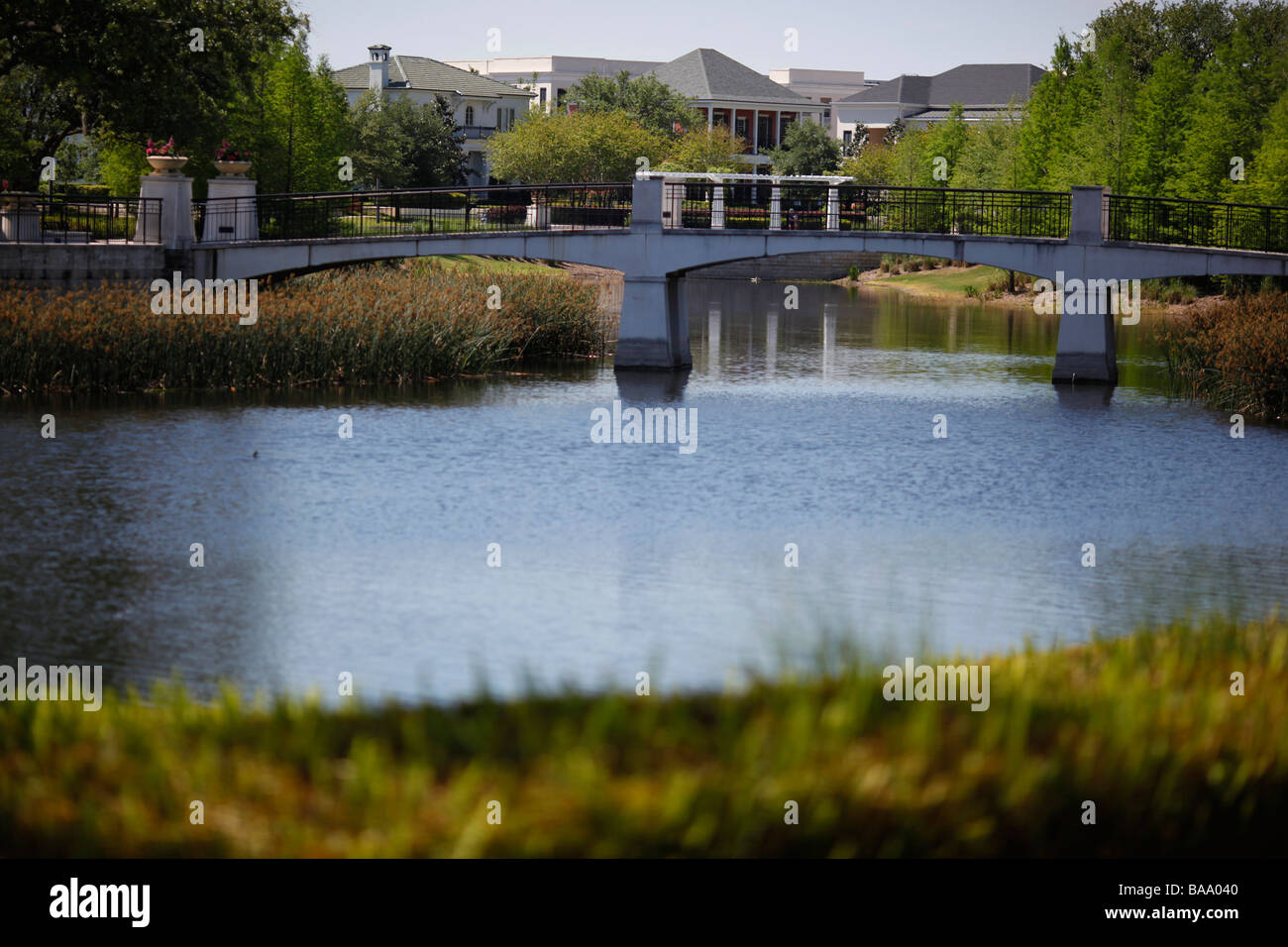 pretty view of a walking bridge over a lake in a built up community ...