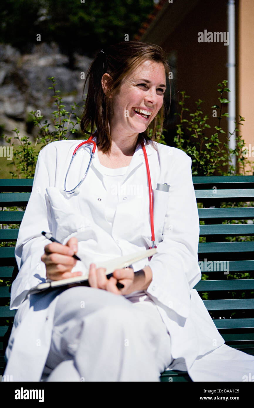 A doctor sitting on a bench taking notes, Sweden Stock Photo - Alamy