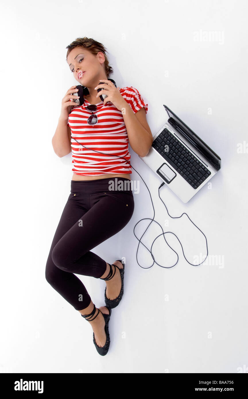 laying woman with laptop and headphone Stock Photo - Alamy