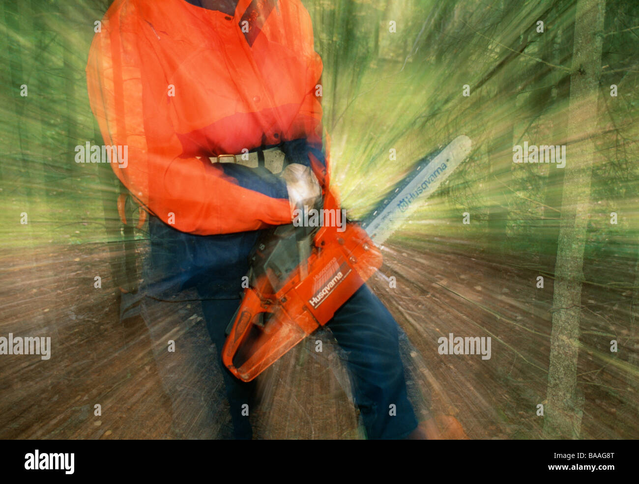 Person standing in forest holding chainsaw Stock Photo - Alamy