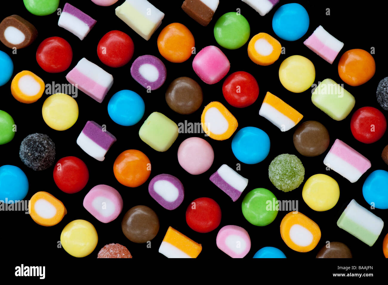 Multicoloured dolly mixtures and smarties sweets pattern on black Stock ...