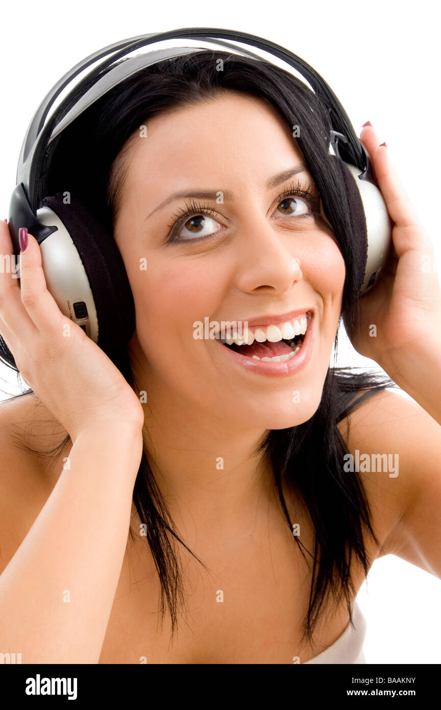 front view of smiling female enjoying music against white backgr Stock ...